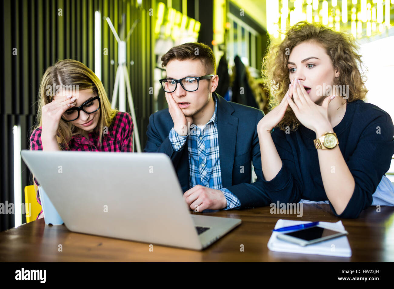 Three upset friends online using a laptop with problems in a coffee ...