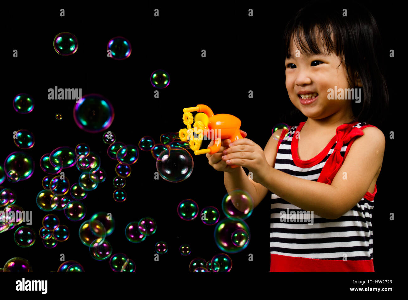 Asian Chinese children Playing Soap Bubbles in black background indoor ...