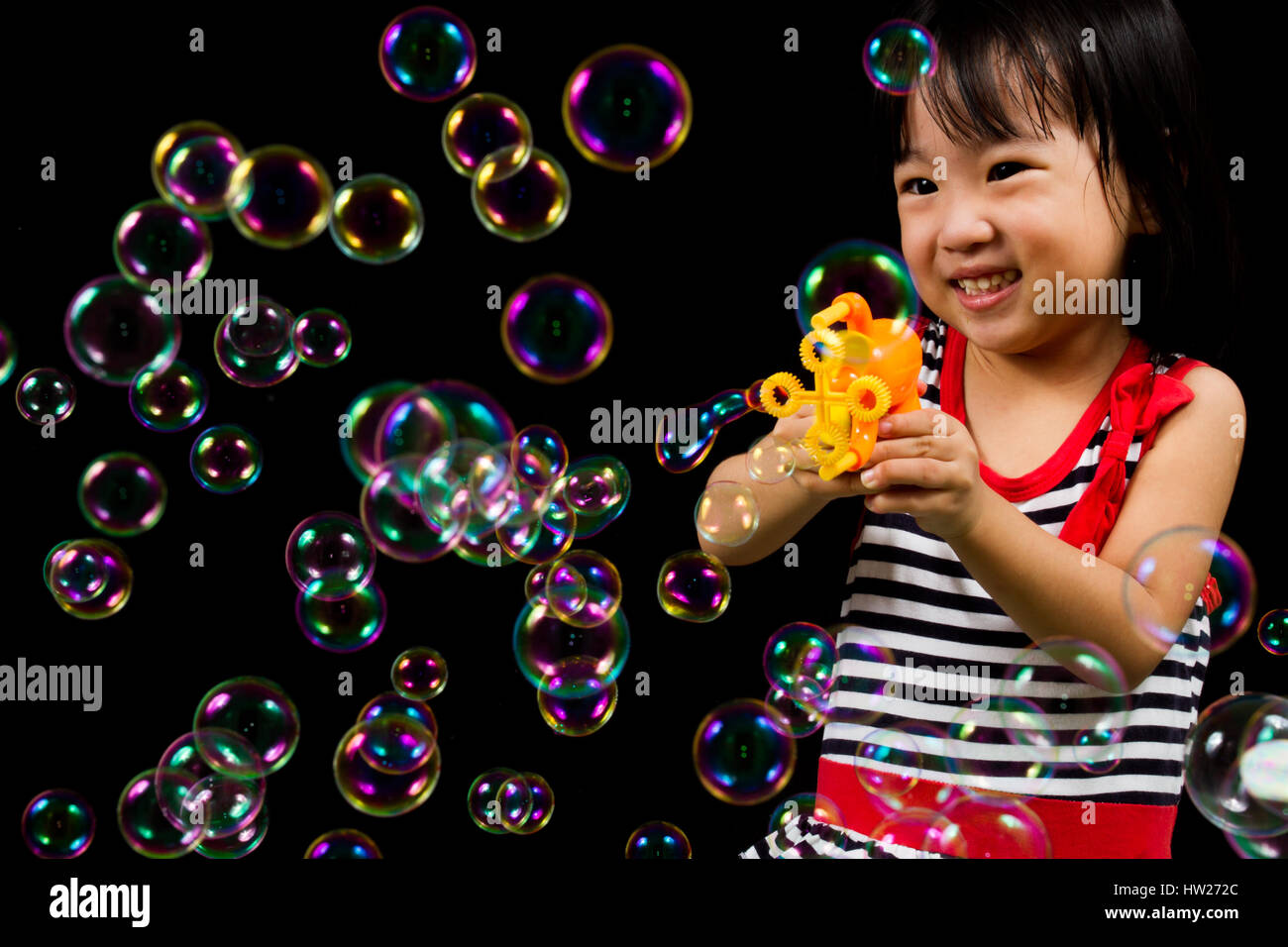 Asian Chinese children Playing Soap Bubbles in black background indoor ...