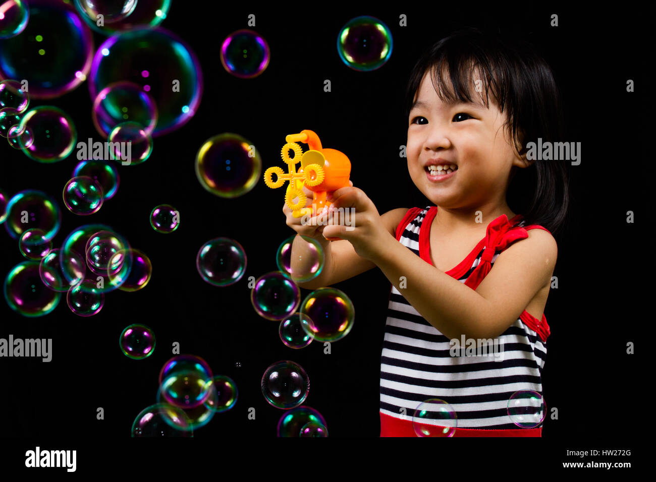 Asian Chinese children Playing Soap Bubbles in black background indoor ...