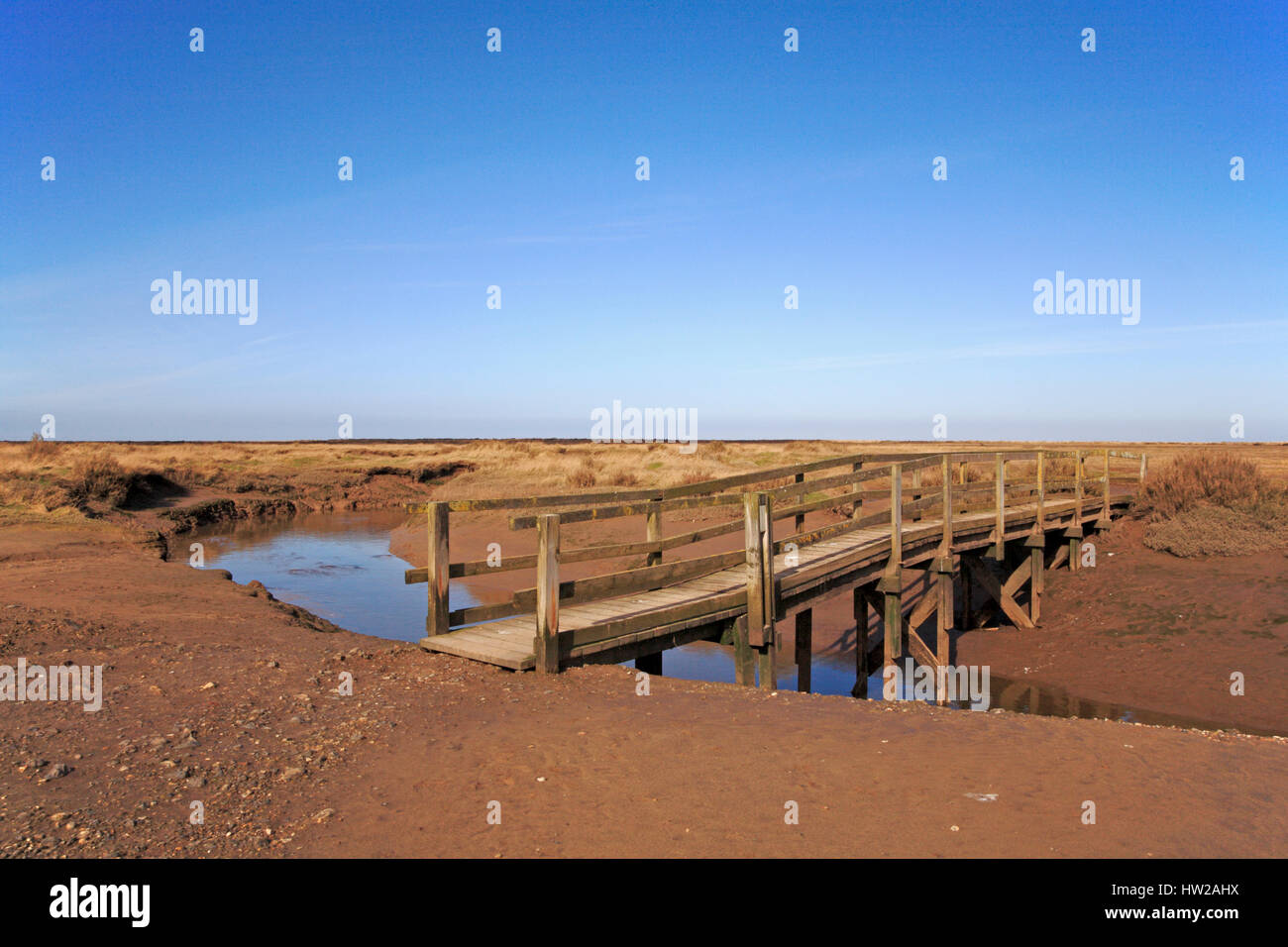 A view of a wooden bridge over a tidal creek on salt marshes on the ...