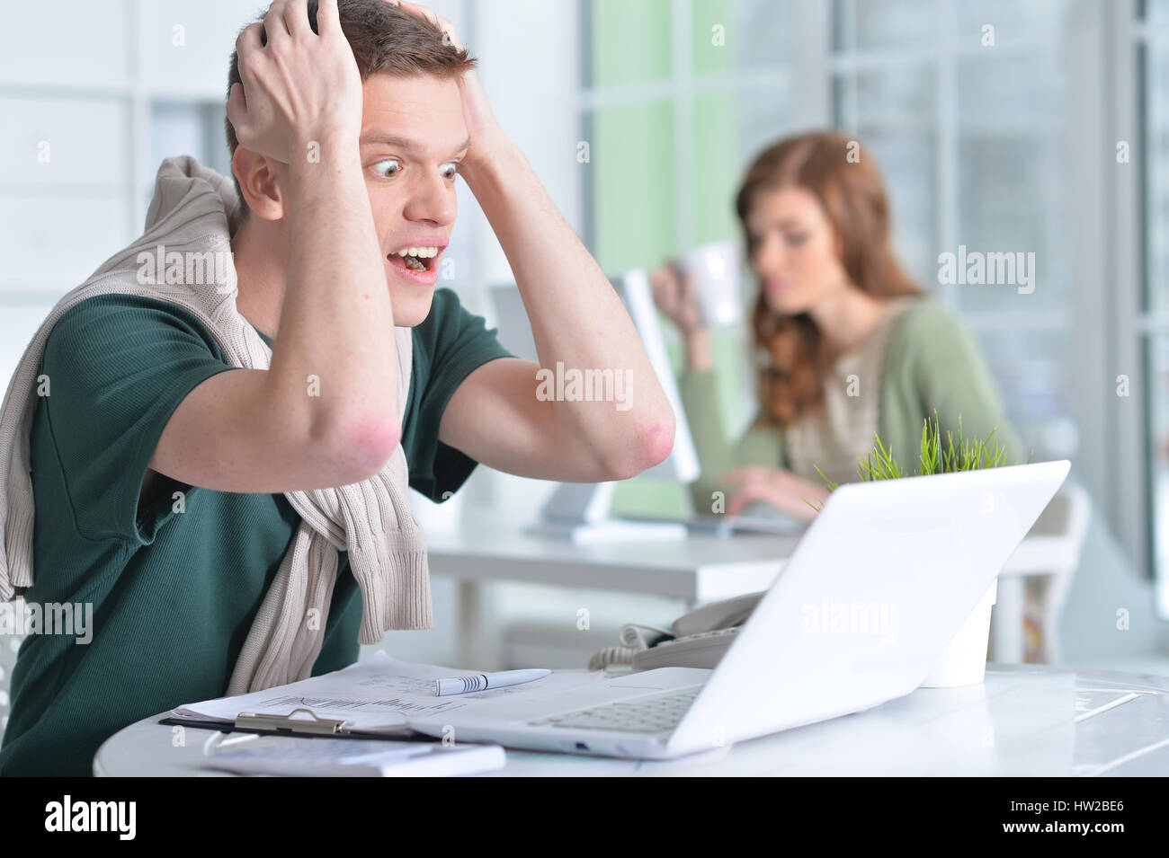 Young man working in office with a laptop Stock Photo - Alamy