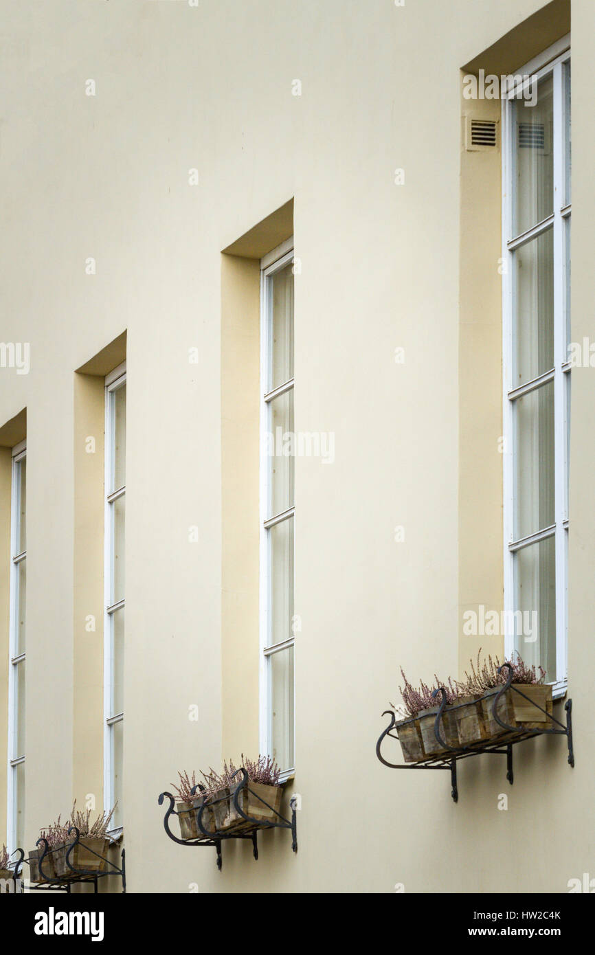 Beige painted wall with four windows Stock Photo - Alamy