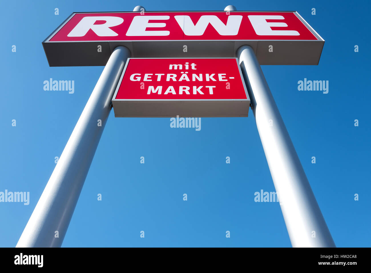 REWE sign (with beverage store) against blue sky. REWE operates ...