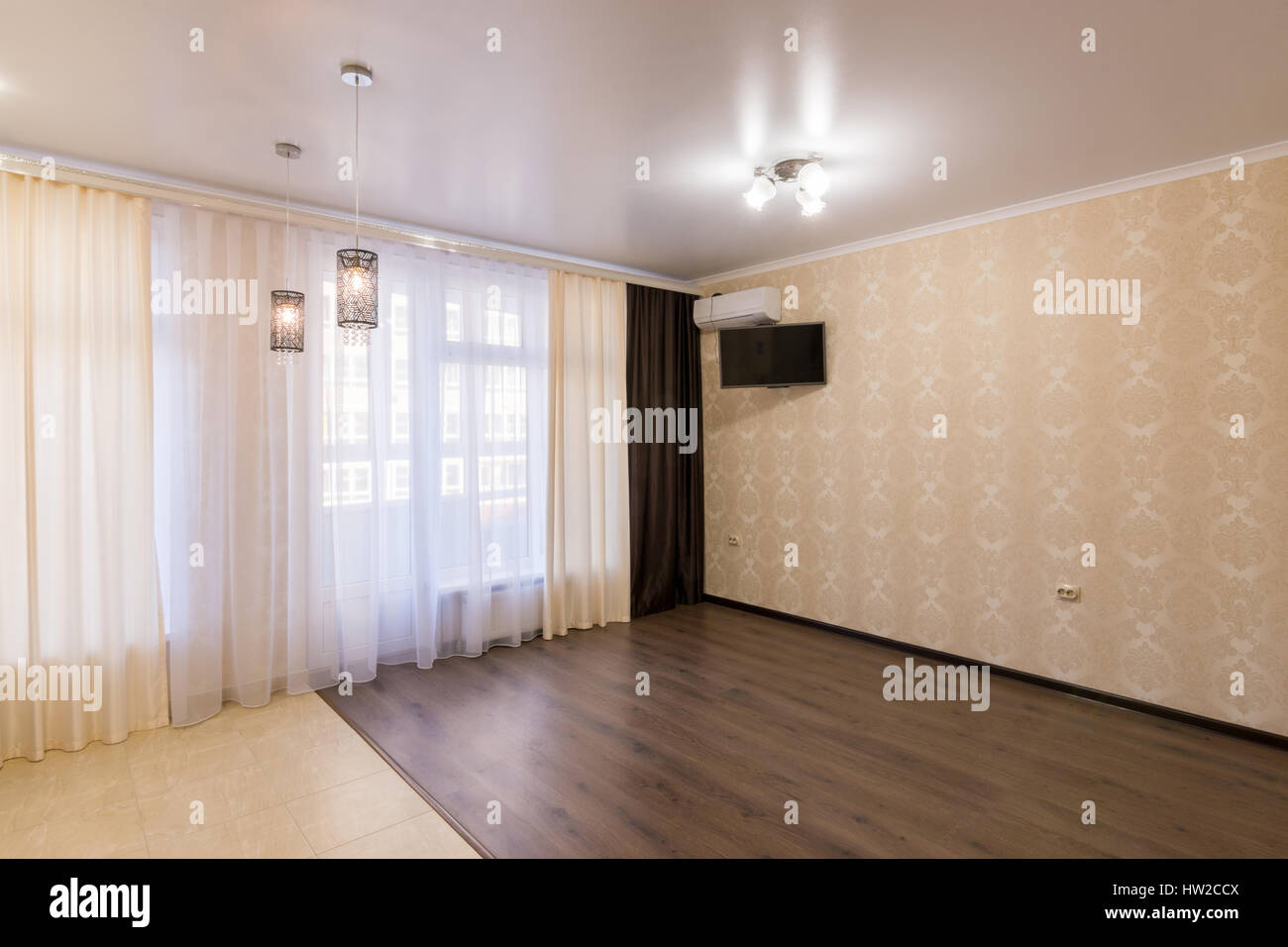 The interior of a small room with a large window without furniture ...