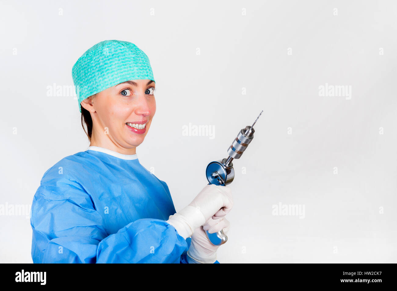 Female surgeon smiling, holding antique, old fashioned medical drill on ...