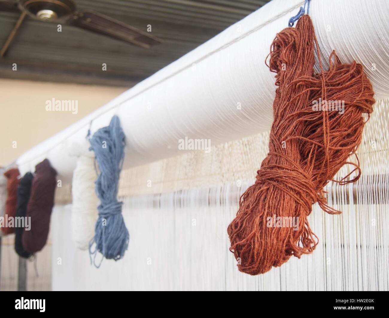 Skiens of natural dyed yarn hanging on a loom Stock Photo - Alamy