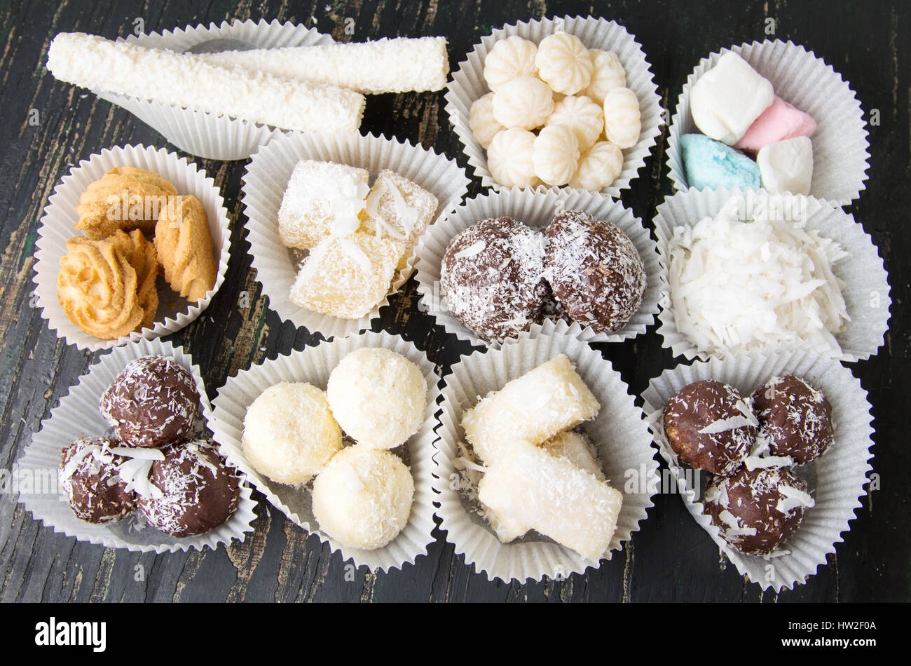 Various coconut candies and desserts in white paper cups Stock Photo ...