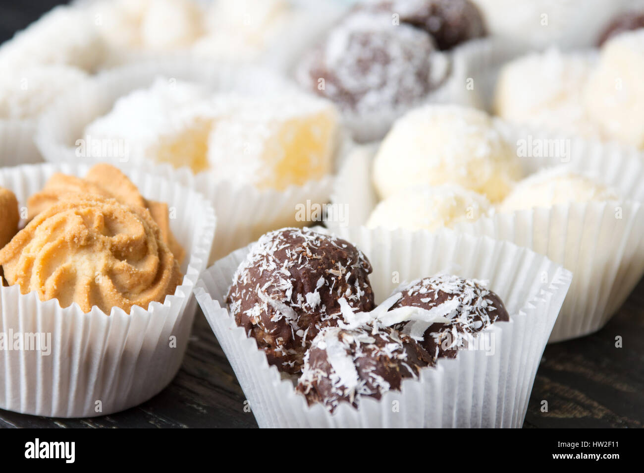 Various coconut candies and desserts in white paper cups Stock Photo ...