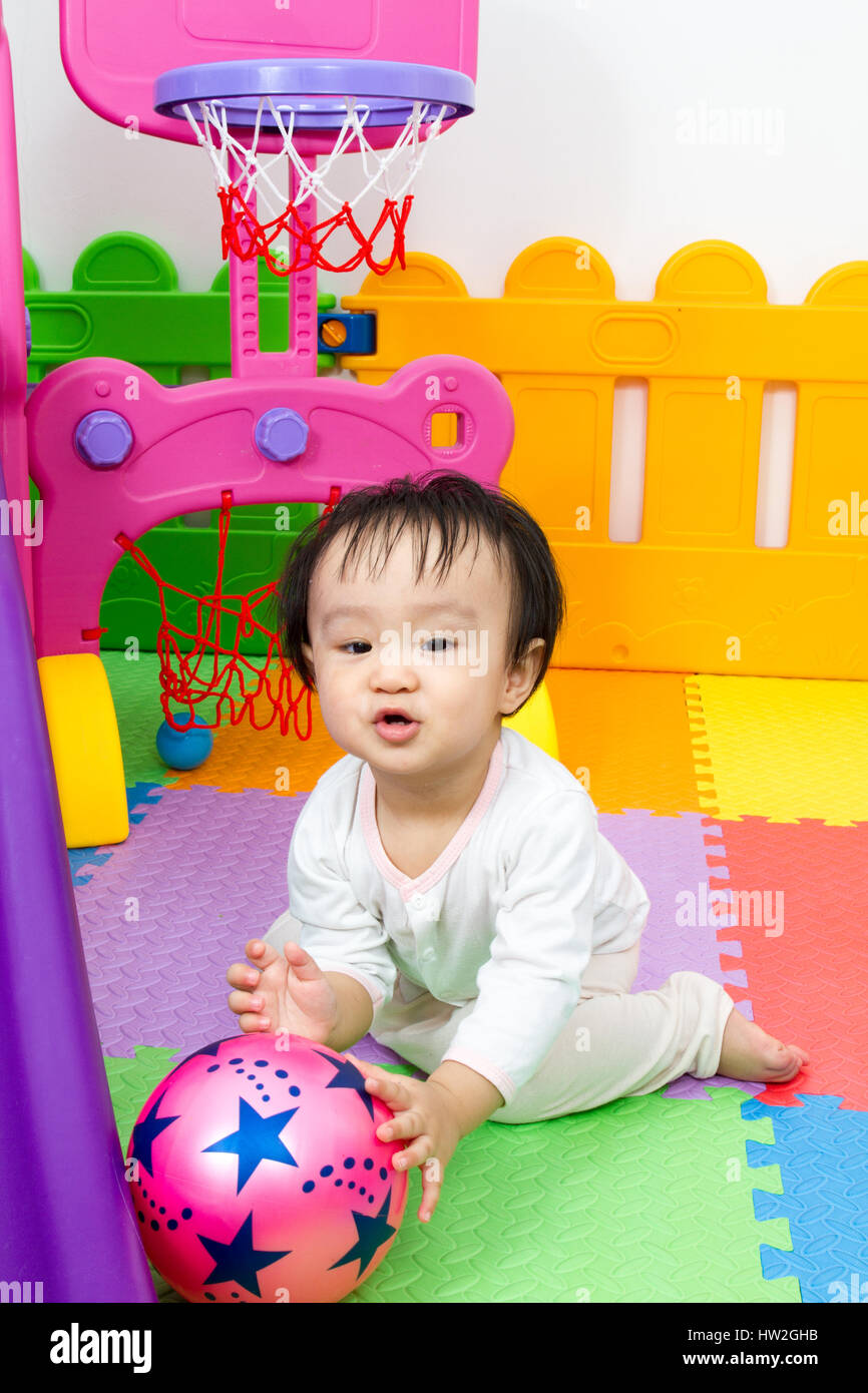 Asian Chinese little boy playing basketball at indoor colourful ...