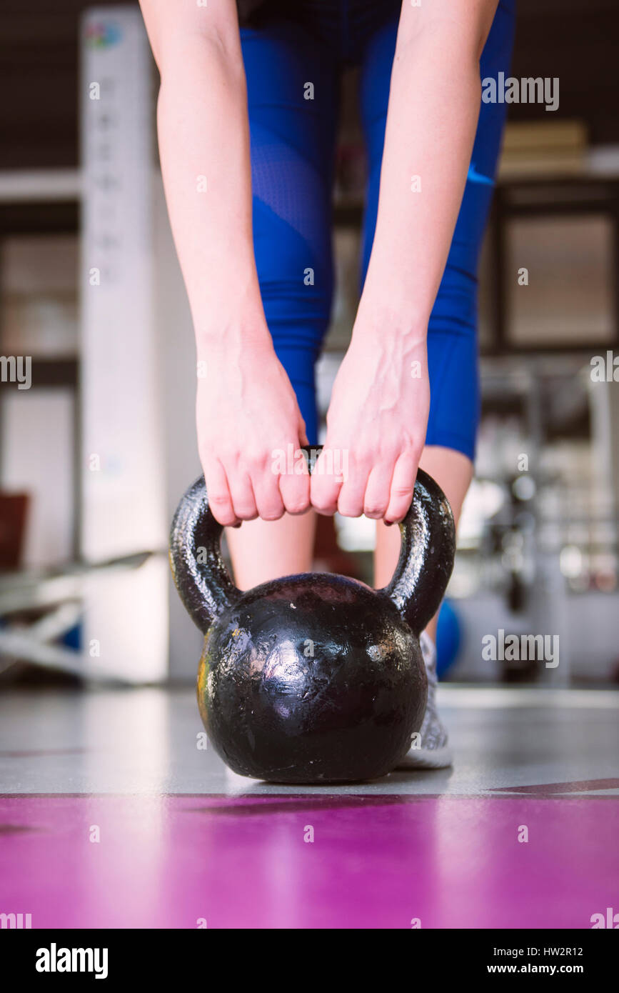 Young adult fitness woman doing swing exercise with a kettlebell as a ...
