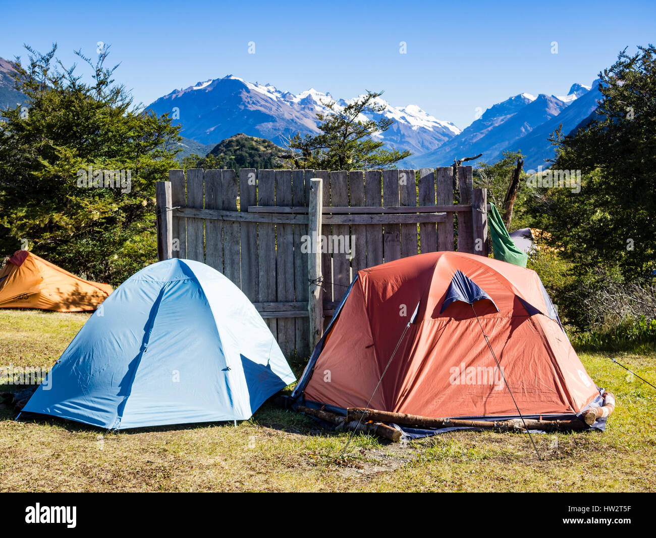 Tents on campsite in El Chalten, wooden fence as shelter against the ...
