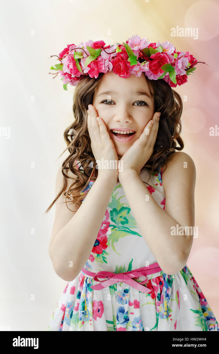 Portrait of cute surprised little girl in nice spring dress, with ...