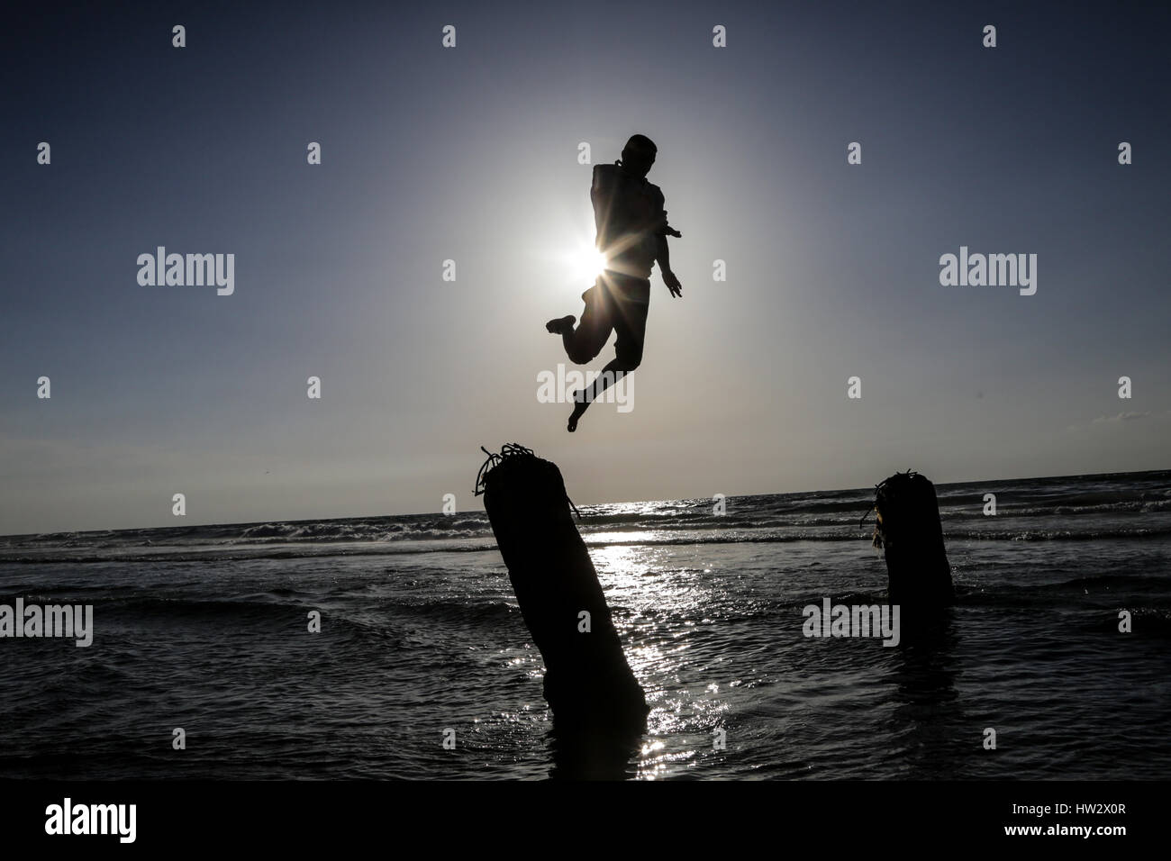 Gaza. 16th Mar, 2017. A Palestinian youth jumps into the seawater on a ...