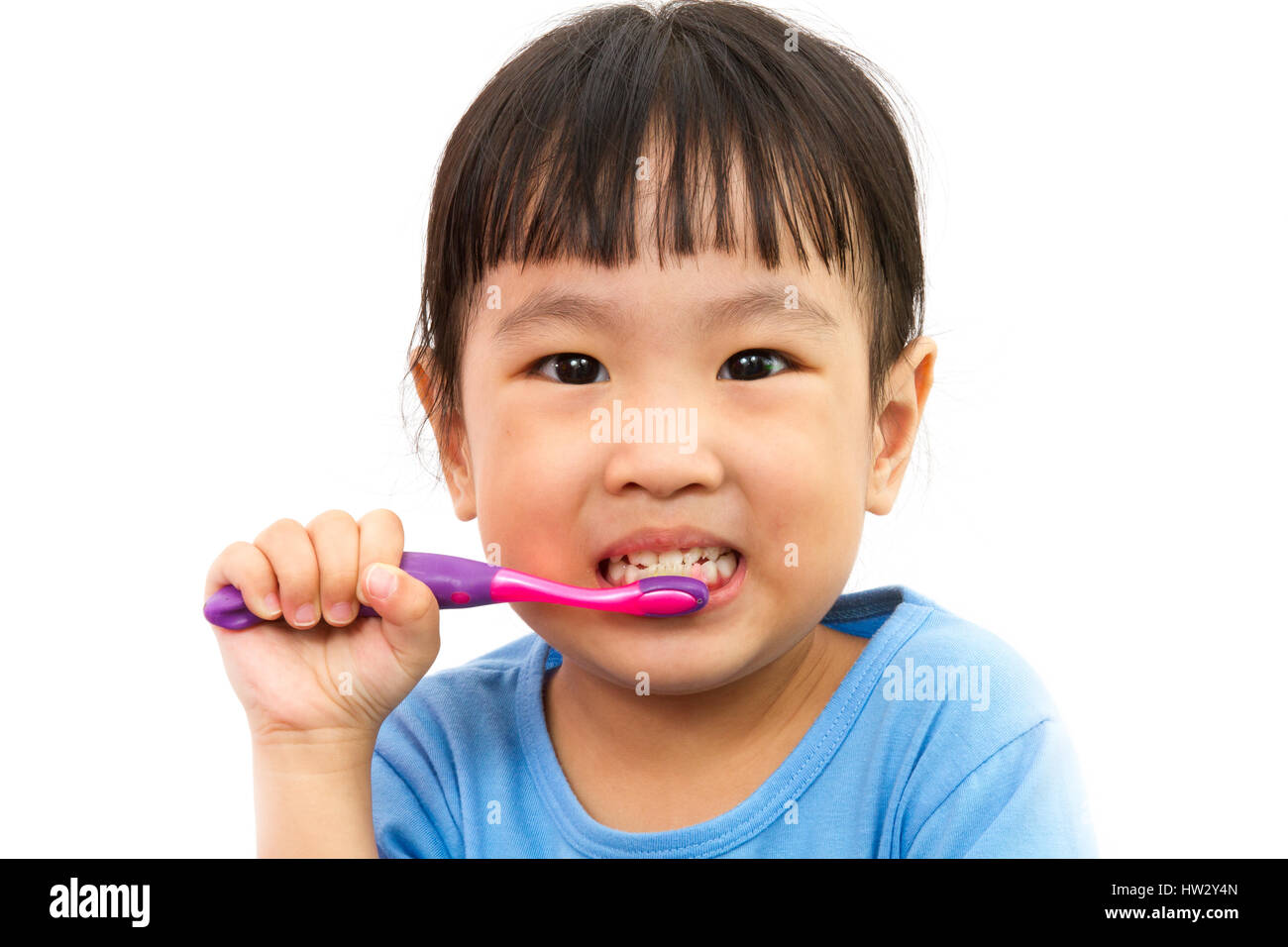 Chinese little girl brushing teeth in plain white isolated background ...