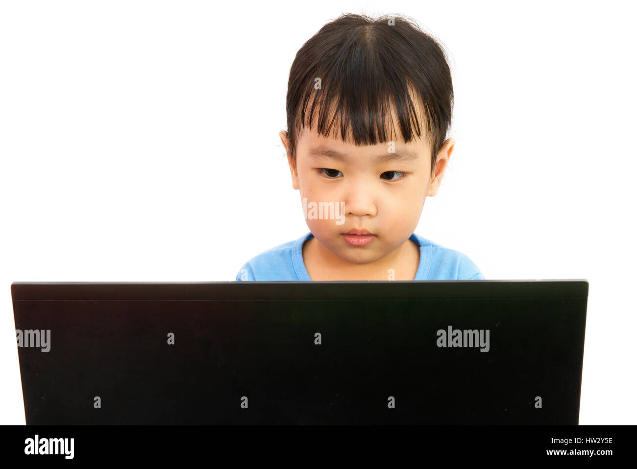 Chinese little girl using laptop in plain isolated white background ...