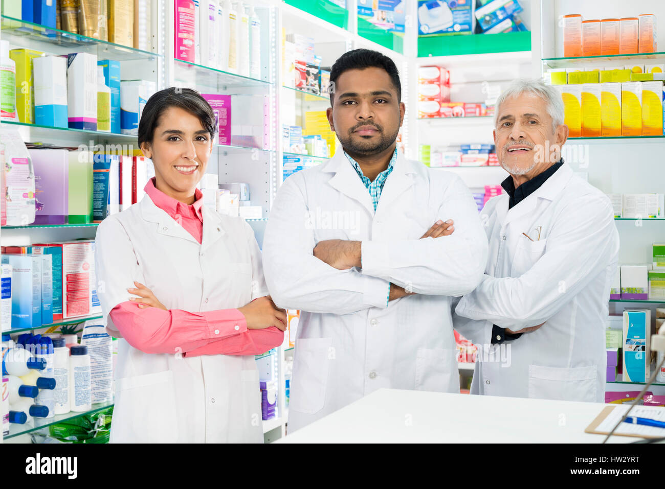Portrait of confident multiethnic male and female pharmacists standing ...