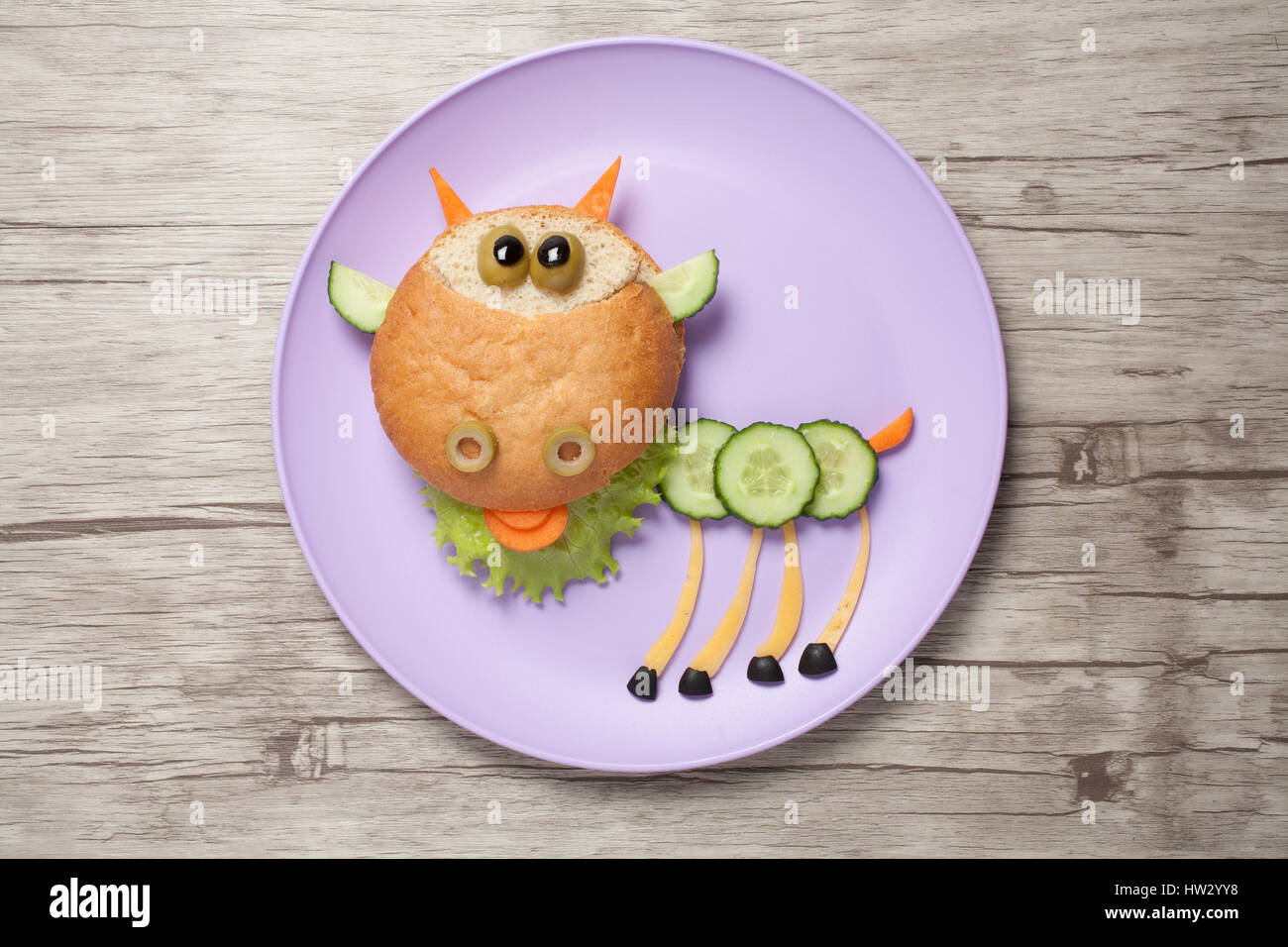 Goat made of bread, cheese and vegetables on plate and desk Stock Photo ...