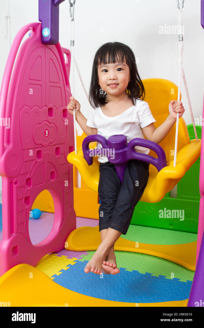 Asian Chinese children playing on swing at indoor playground Stock ...