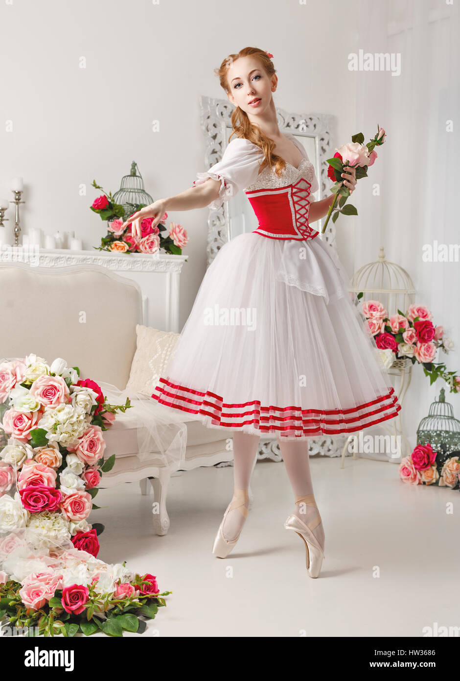 A sweet ballerina in a stage costume holds a bouquet of spring flowers ...