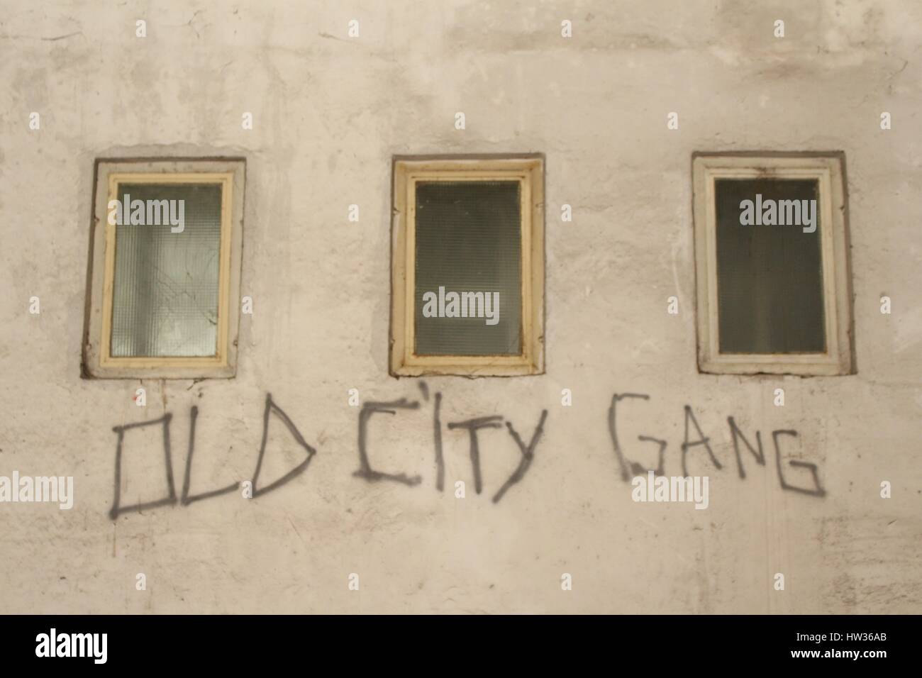 An Old City Gang mural below three fogged out windows in Porec, Croatia ...
