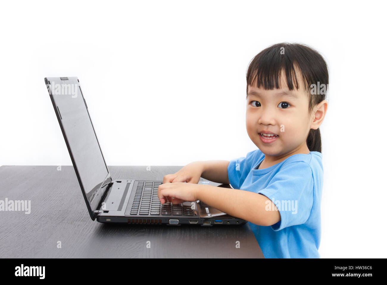 Chinese little girl using laptop in plain isolated white background ...