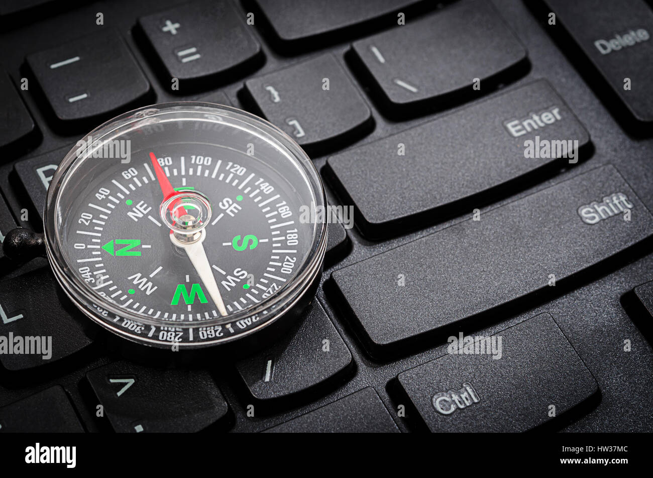 Black computer keyboard and compass showing internet navigation concept ...