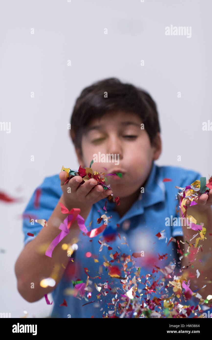 Happy kid celebrating party with blowing confetti Stock Photo - Alamy