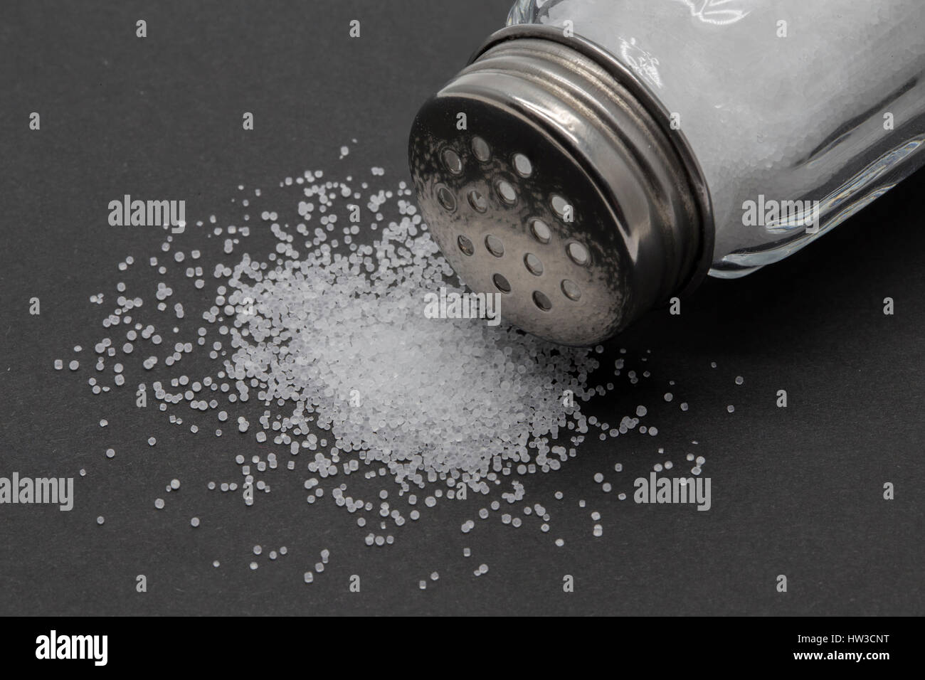 Spilled salt on black background Stock Photo - Alamy