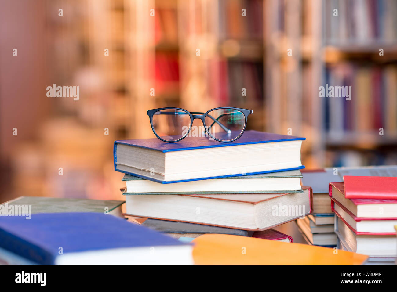 Books with eyeglasses at the library Stock Photo - Alamy