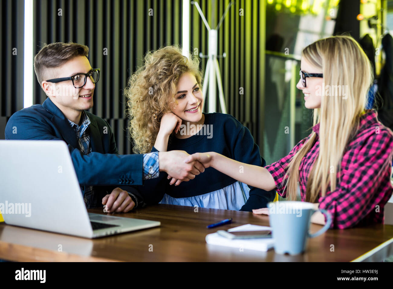 Young freelancers are using gadgets, talking and smiling while working ...