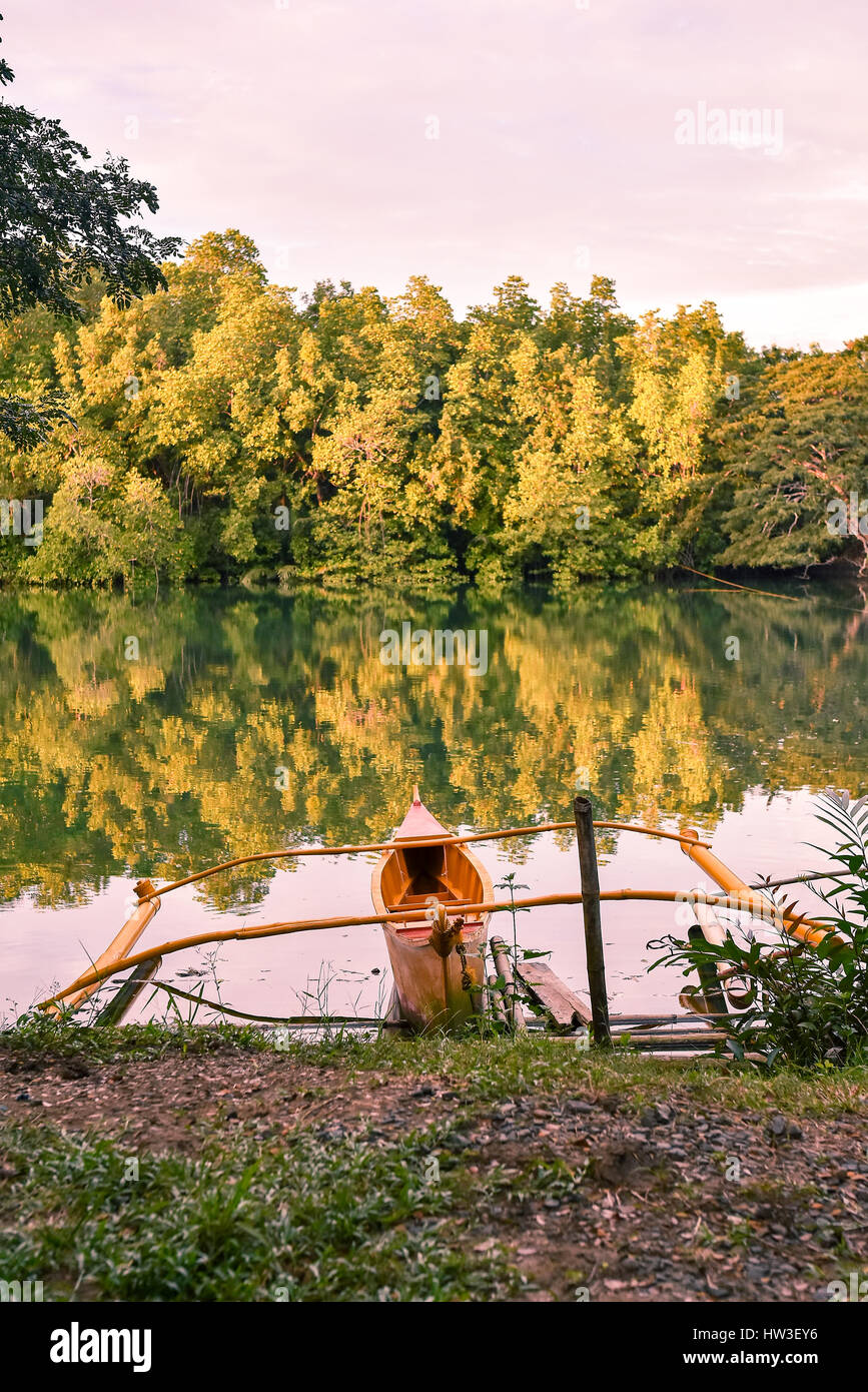 A Filipino traditional fisherman's pump boat moored up as the sunsets ...