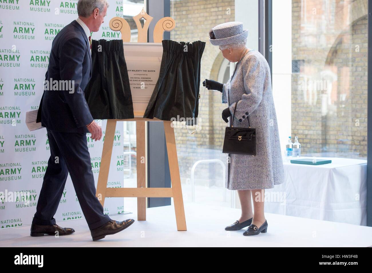 Queen Elizabeth II unveils a plaque during the official reopening of ...