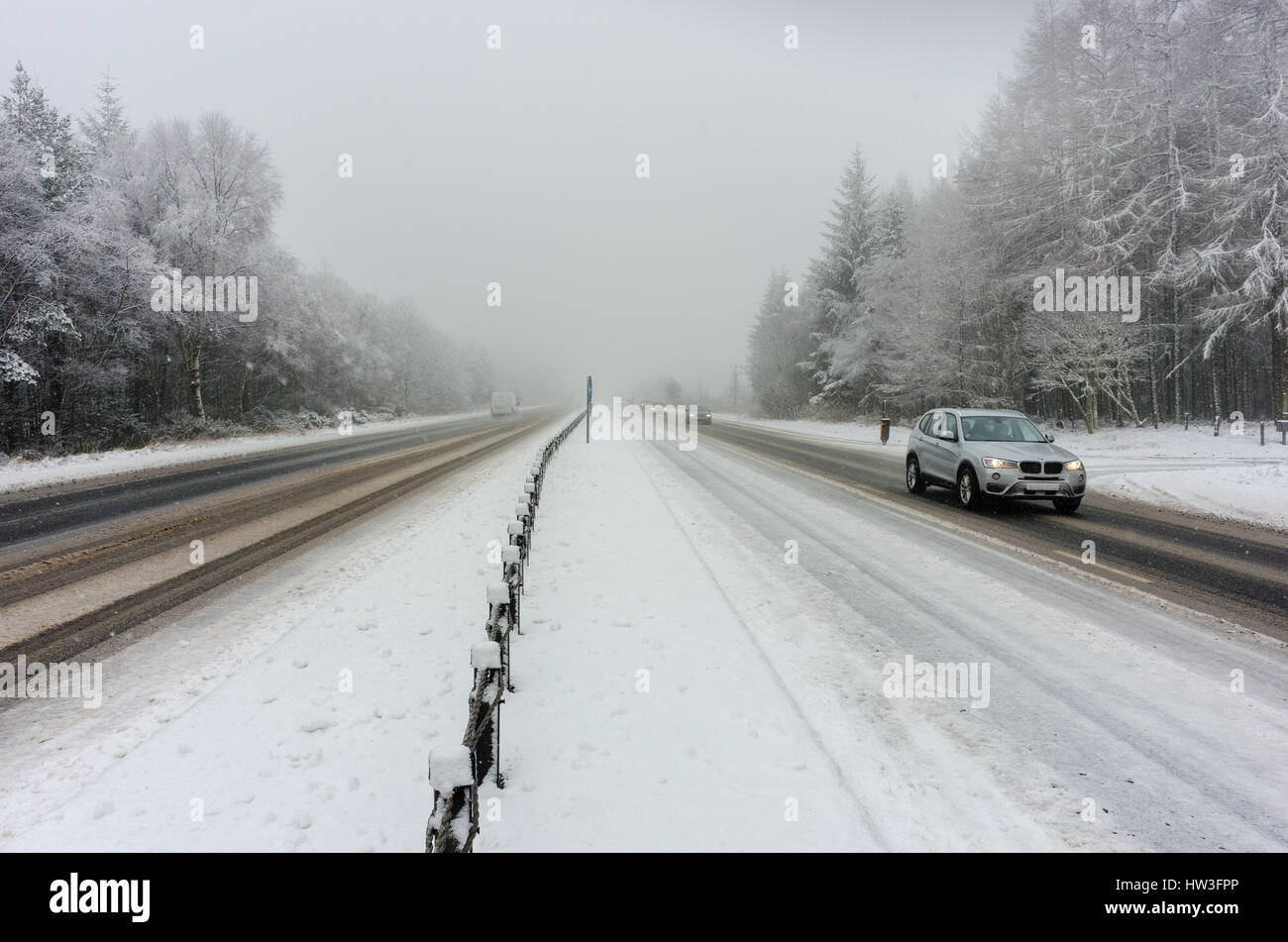 Heavy snow covers the road and results in hazardous driving conditions ...