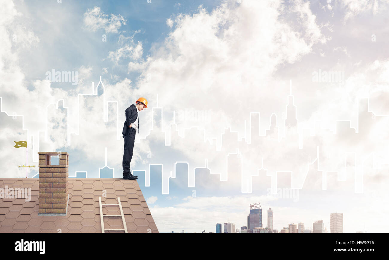 Engineer man standing on roof and looking down. Mixed media Stock Photo ...