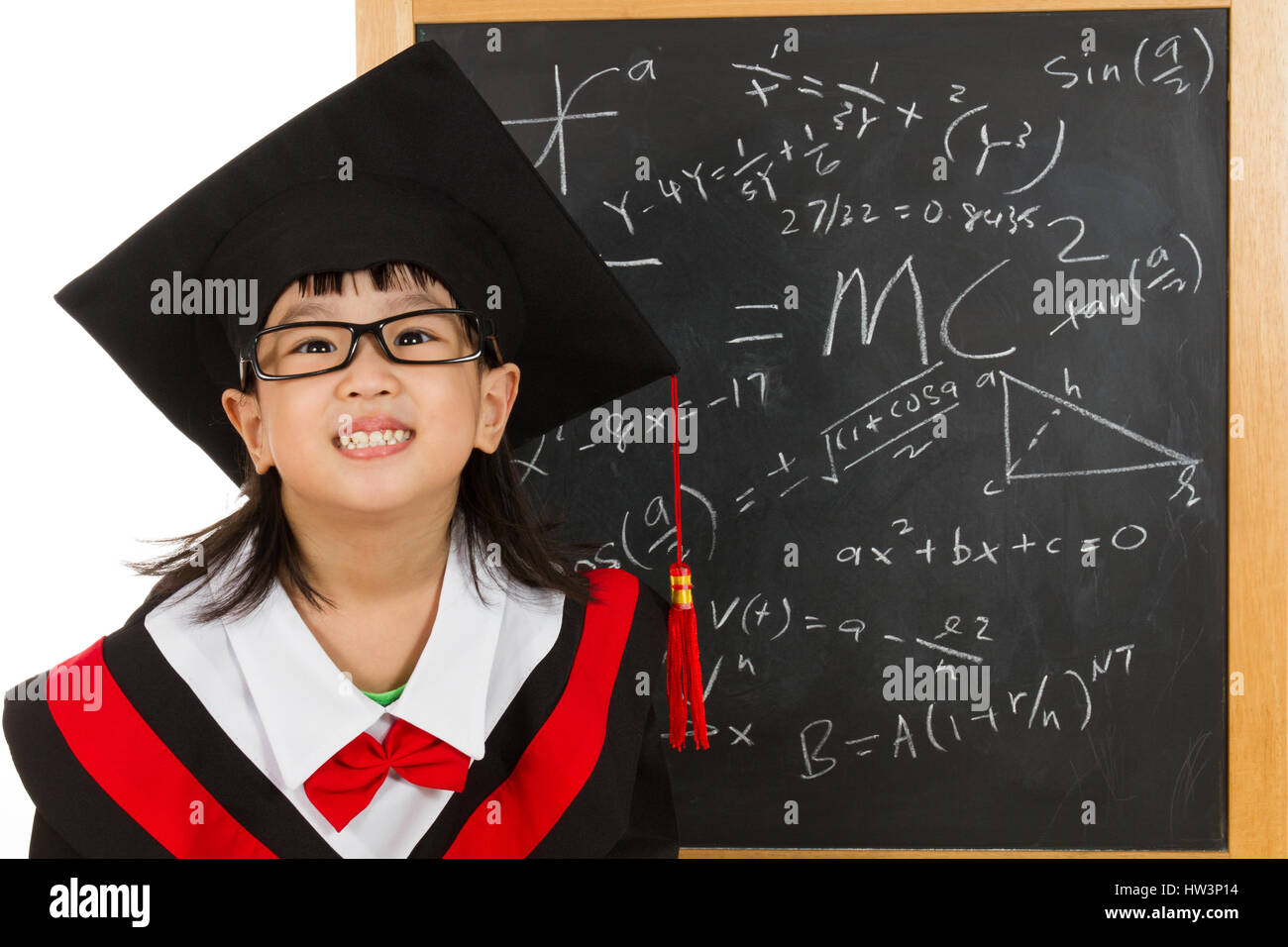 Asian Chinese children in graduation gown againts blackboard or ...