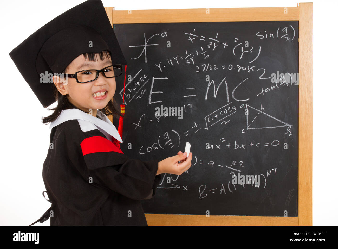 Asian Chinese children in graduation gown againts blackboard or ...