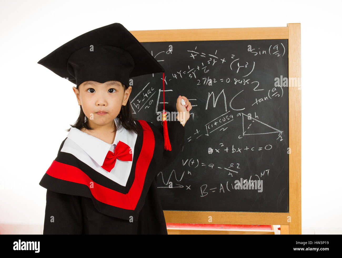 Asian Chinese children in graduation gown againts blackboard or ...