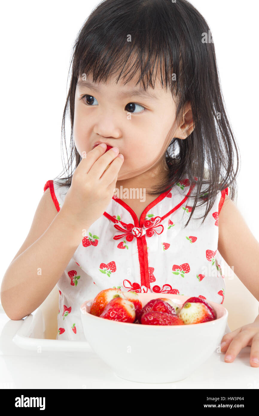 Asian Chinese children eating strawberries in plain white background ...