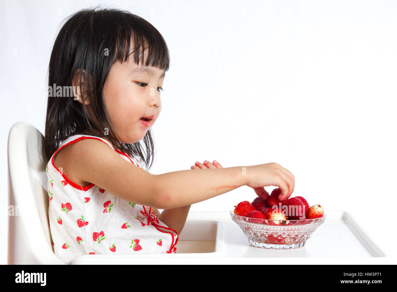 Asian Chinese children eating strawberries in plain white background ...