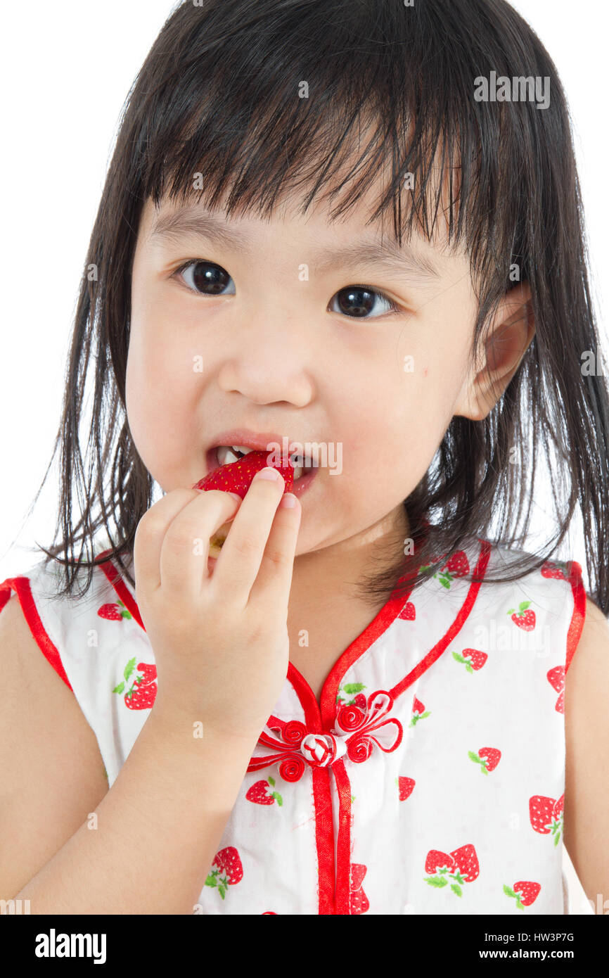 Asian Chinese children eating strawberries in plain white background ...