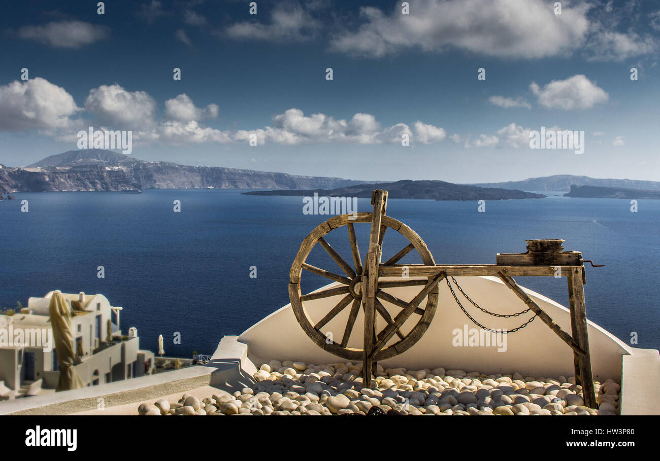 An old spindle on a roof with the Santorini landscape background ...