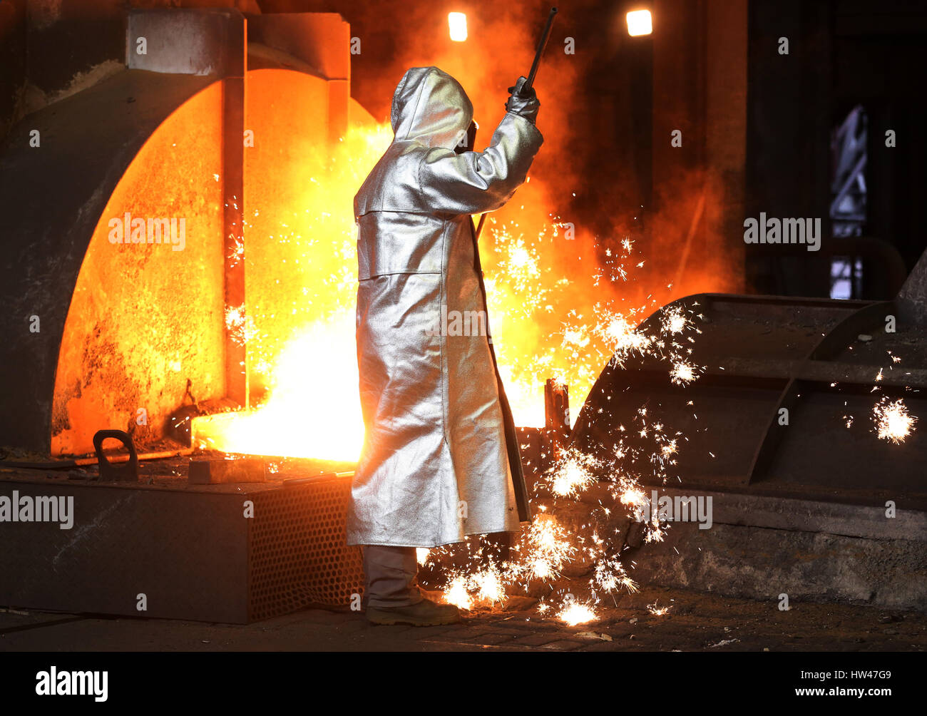 A steel worker checks the quality of steel in furnace no. 8 at ...