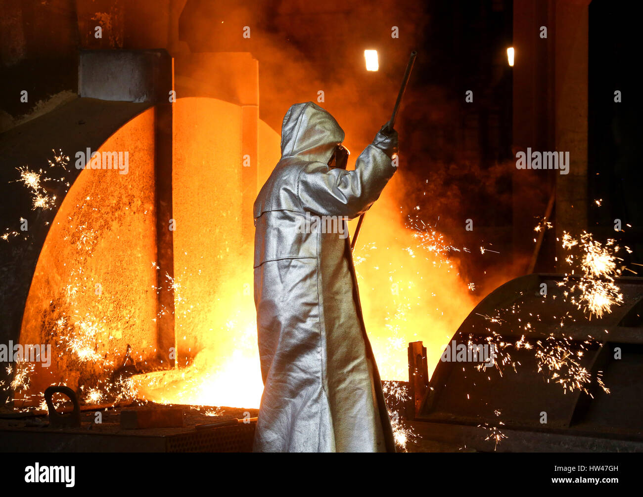 A steel worker checks the quality of steel in furnace no. 8 at ...