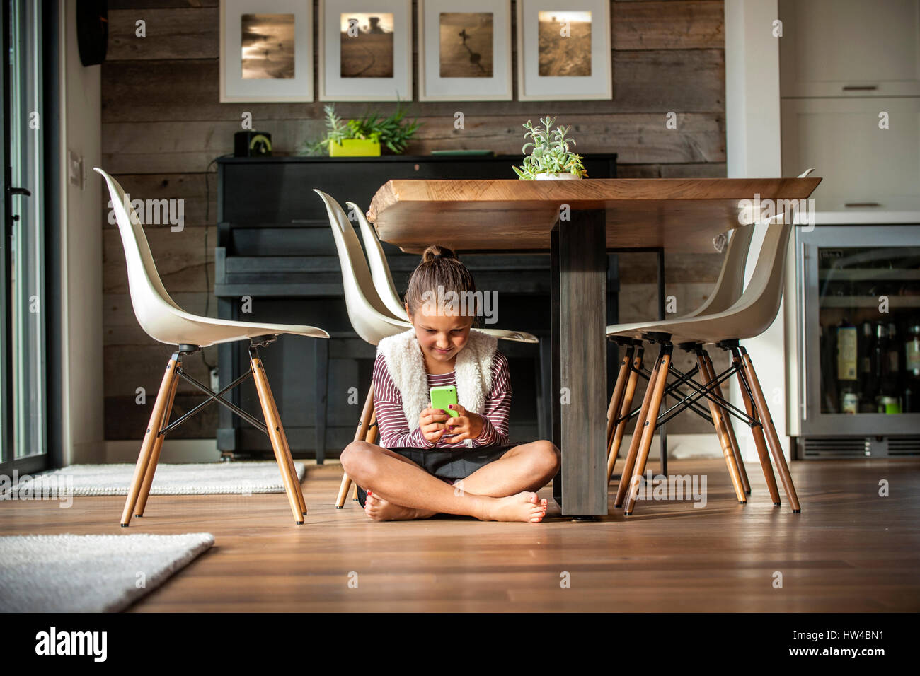 Girl sitting on floor texting on cell phone Stock Photo - Alamy