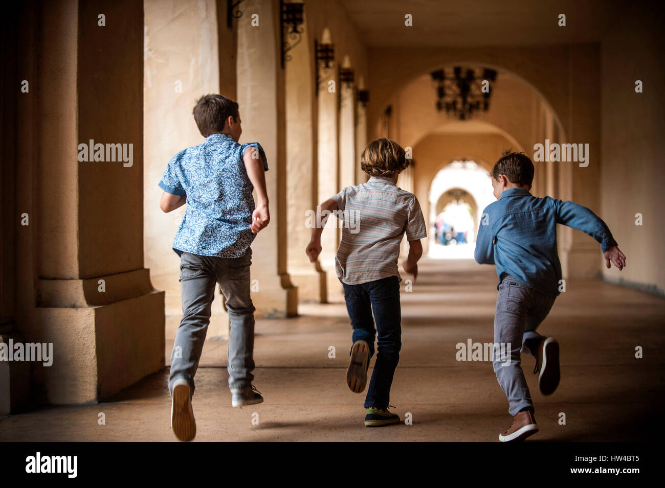 Brothers running near pillars Stock Photo - Alamy