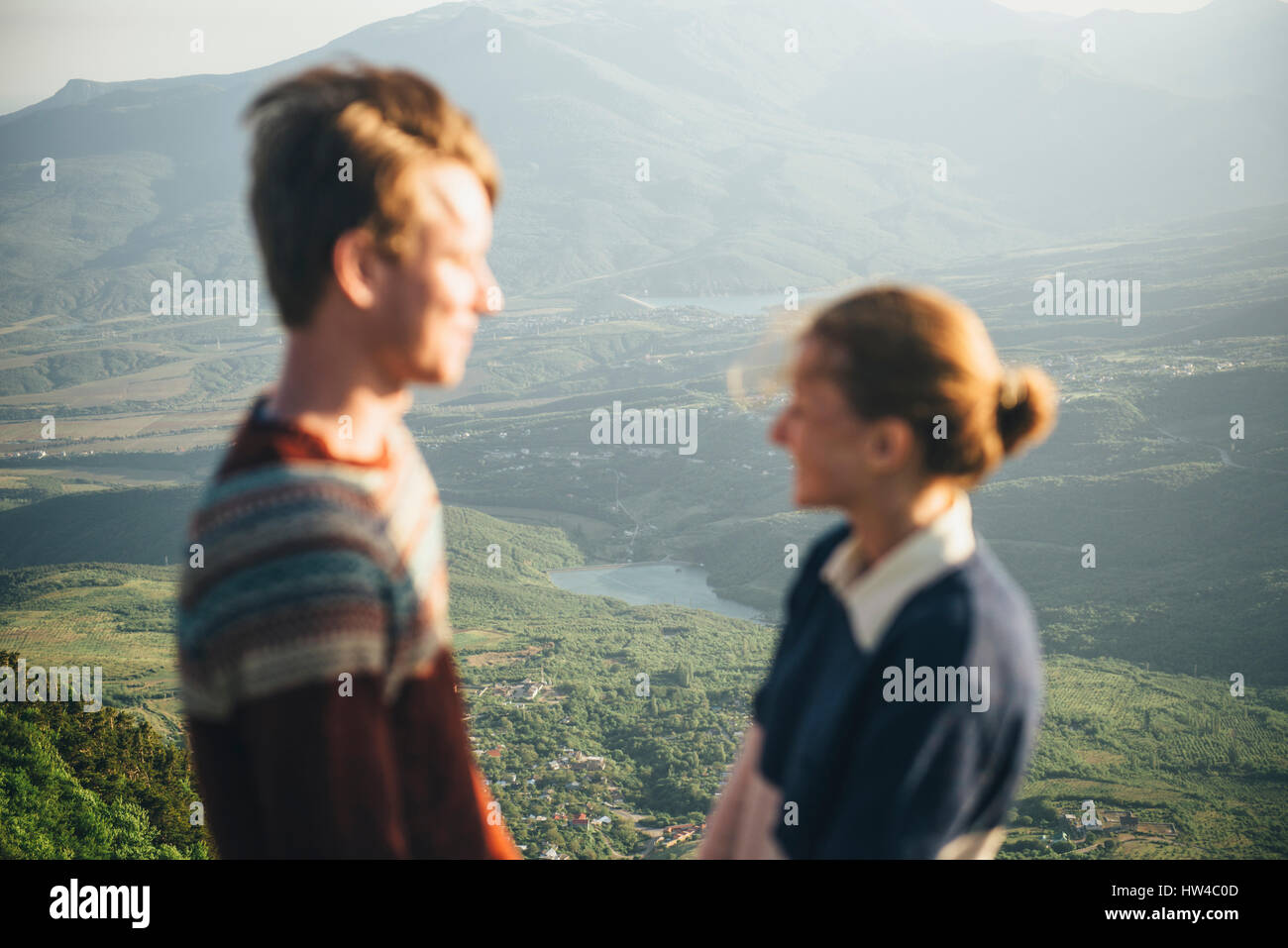 Caucasian couple standing on mountain over valley Stock Photo - Alamy