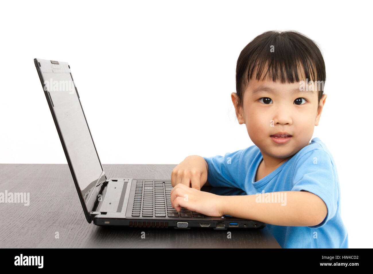Chinese little girl using laptop in plain isolated white background ...