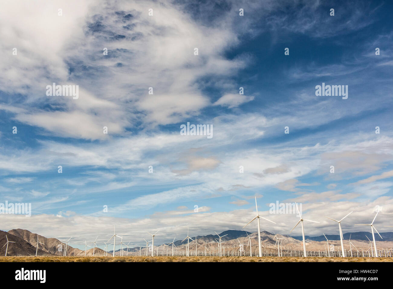 Wind turbines under cloudy sky in remote landscape Stock Photo - Alamy