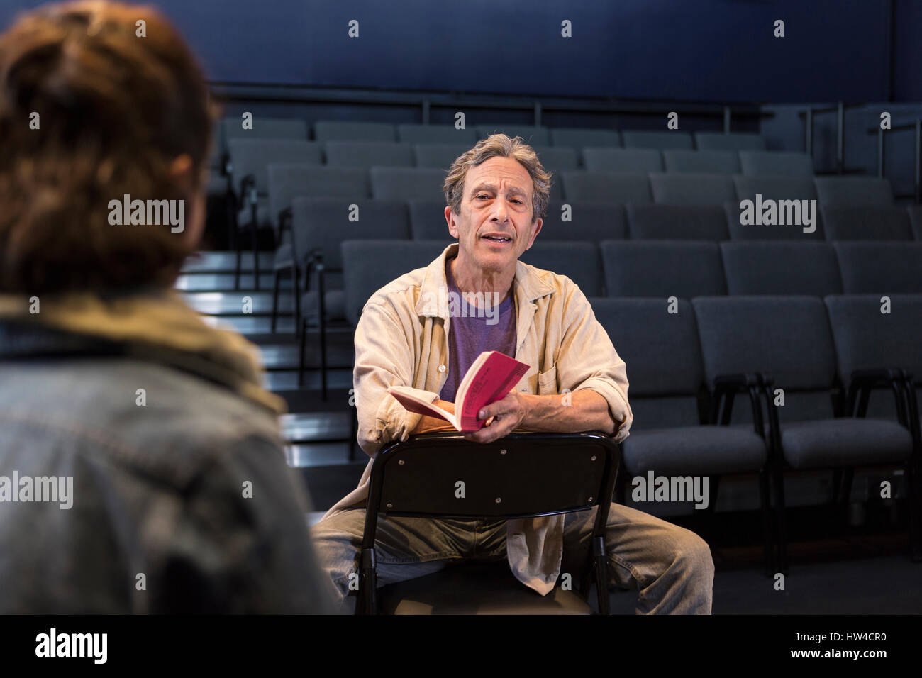 Caucasian actors rehearsing with script in theater Stock Photo - Alamy